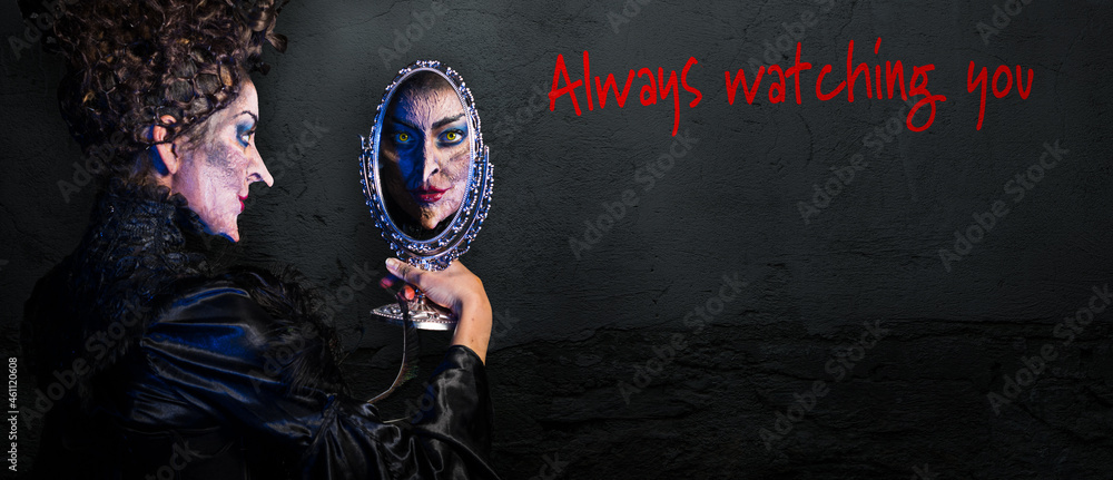 witch with a mirror in her hand looking indirectly into the camera and ...