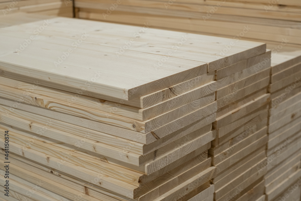 Stacks of pine wood planks in a store or on building site. Natural ...