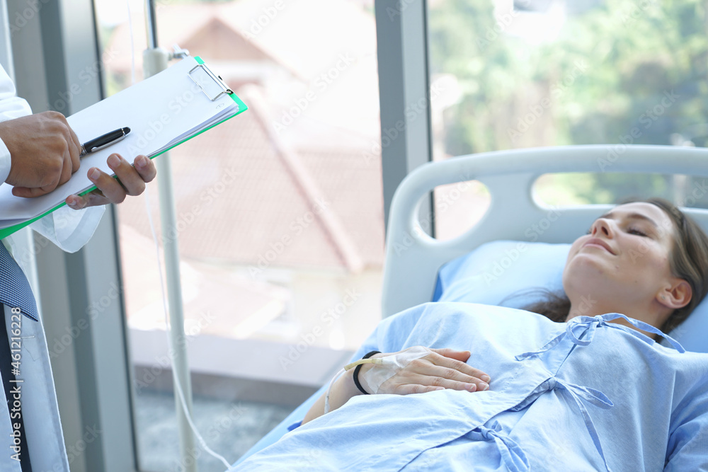 Patient lying on patient's bed in hospital with talking the Doctor ...