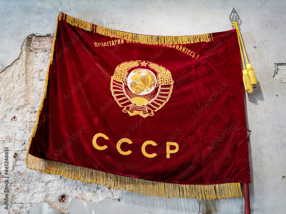 Soviet red banner with the coat of arms of the USSR at the old light ...