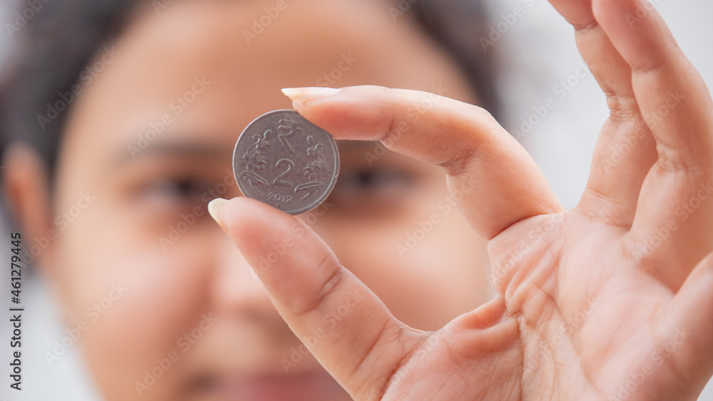 Indian girl showing two-rupee coin hand Stock Photo | Adobe Stock