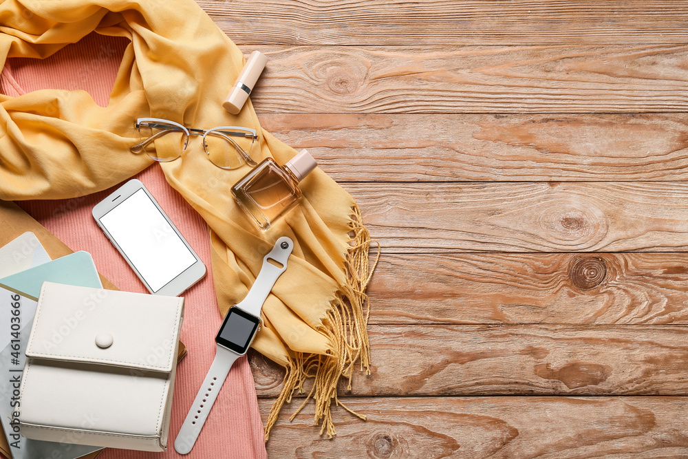 Female clothes, stylish accessories and smartphone on wooden background ...