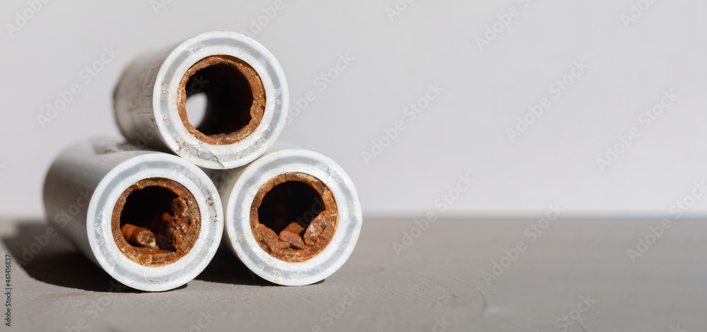 Old broken sludge plumbing polypropylene pipes with red rust and ...