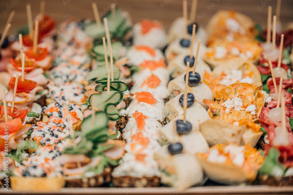 Assortment of tasty appetizers - mini burgers, cheesy canapes, wrap ...
