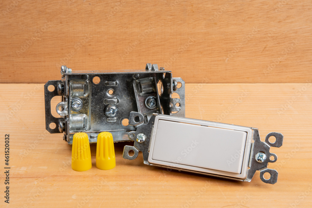 a steel electrical outlet box and a modern square wall light switch on ...