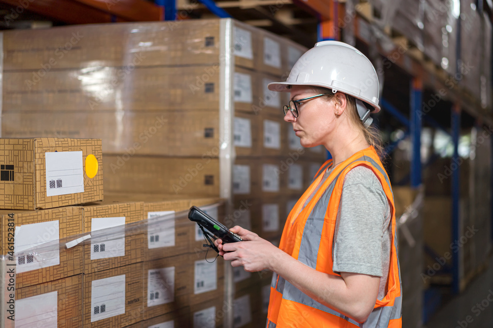 Store worker using a barcode scanner for stock counting in warehouse ...
