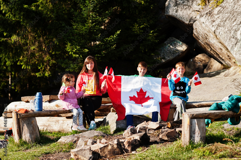 Happy Canada Day. Family of mother with three kids hold large Canadian ...