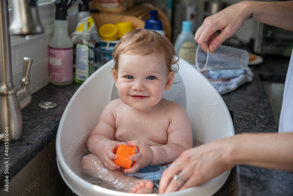 Happy baby boy taking bath in sink. Stock Photo | Adobe Stock
