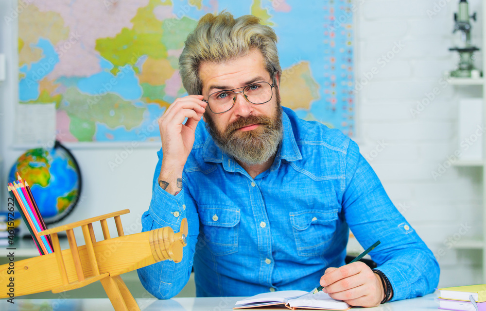 Male Teacher prepares lessons in classroom. Learning, education, school ...