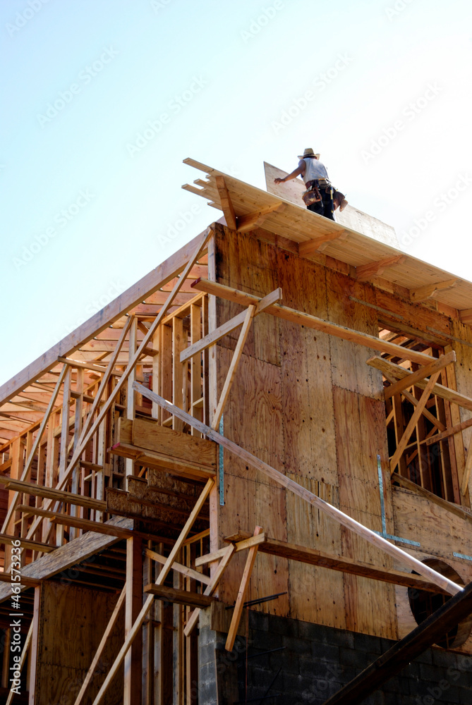 Carpenter installing plywood sheathing over roof framing Stock Photo ...