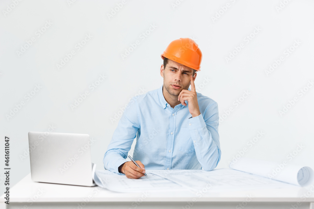 Confident smiling architect in formal wear thinking and working with ...