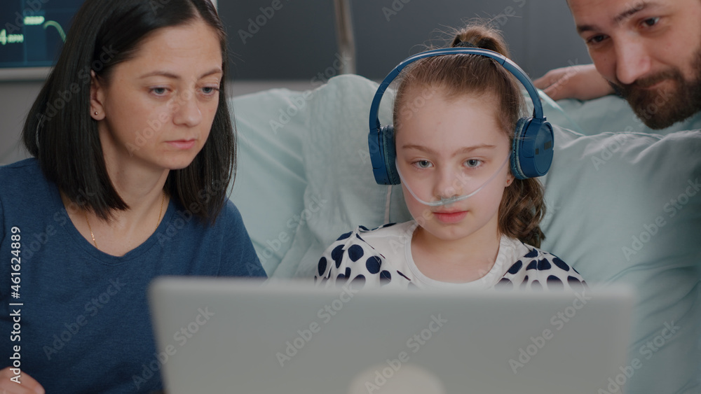 Family sitting beside daughter while playing online videogames using ...