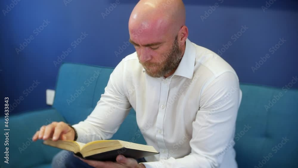 A man holding and Reading A Book with Fingers following The Lines. The ...