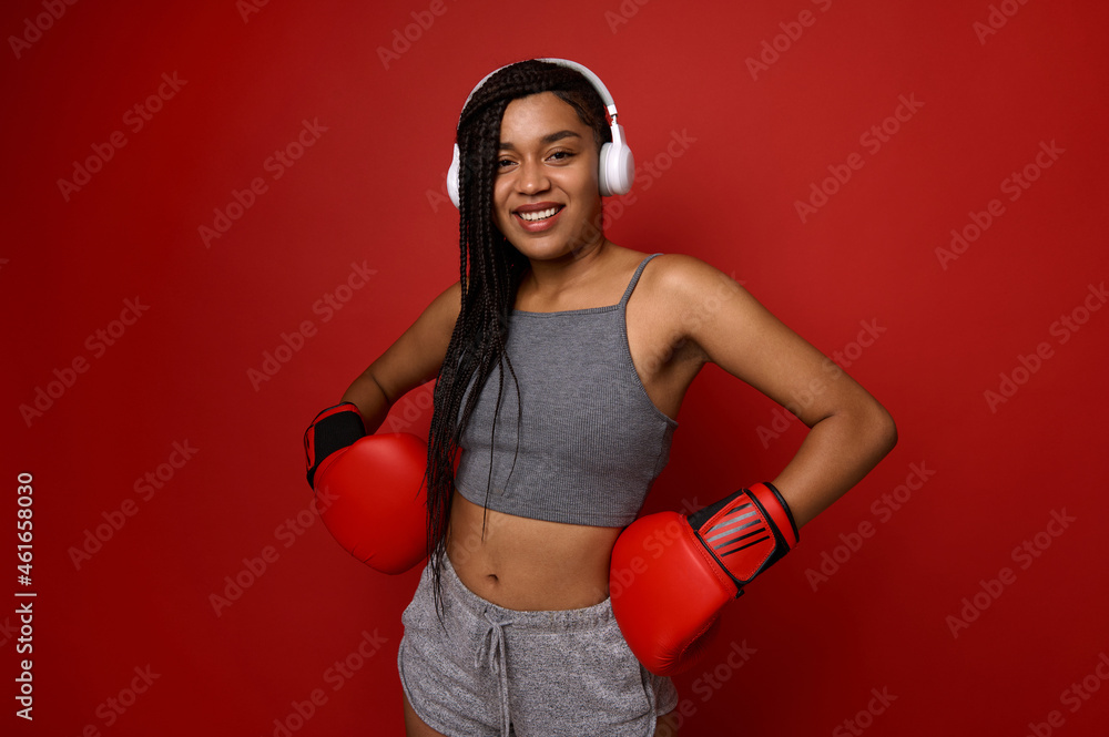 Athlete African woman boxer in wireless headphones and hands in boxing ...