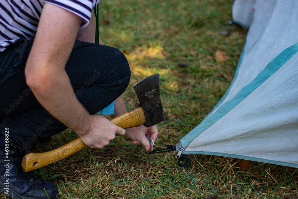 Male camper pitch a tent in the forest. Man helps set up. Man driving ...
