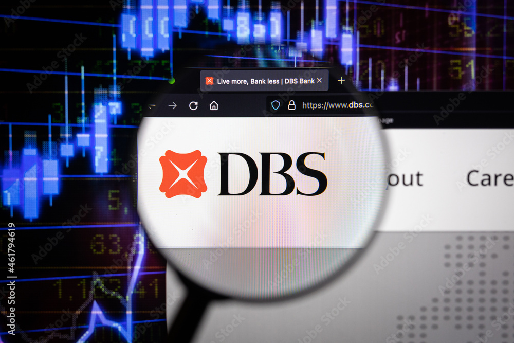 DBS company logo on a website with blurry stock market developments in ...