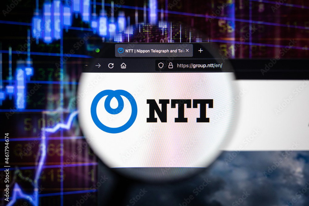 NTT company logo on a website with blurry stock market graphs in the ...