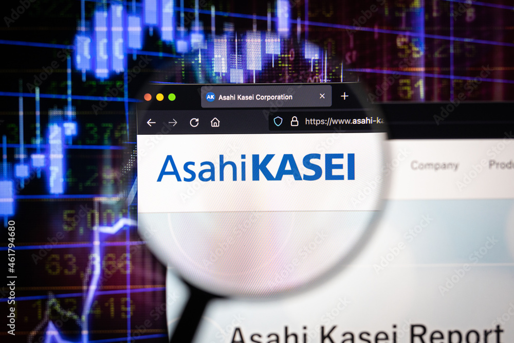 Asahi Kasei company logo on a website with blurry stock market graphs ...