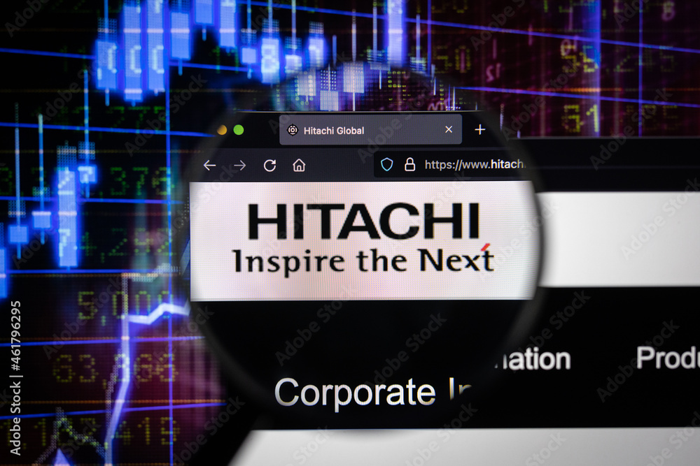 Hitachi company logo on a website with blurry stock market graphs in ...