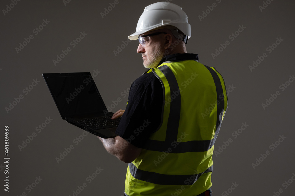 Builder laptop with screen off. Man in uniform of construction worker ...