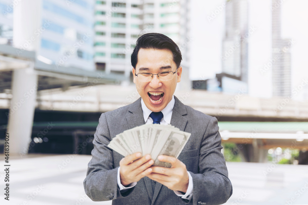 Excited happy face , Asian business man wear a suit holding money US ...