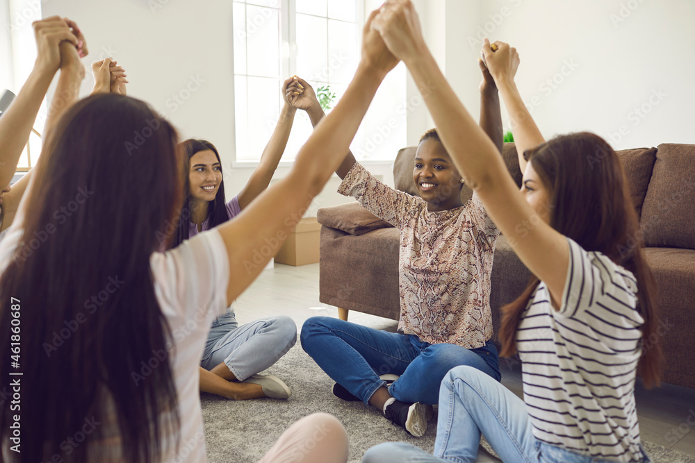 Multiethnic group of happy cheerful confident young women holding hands ...