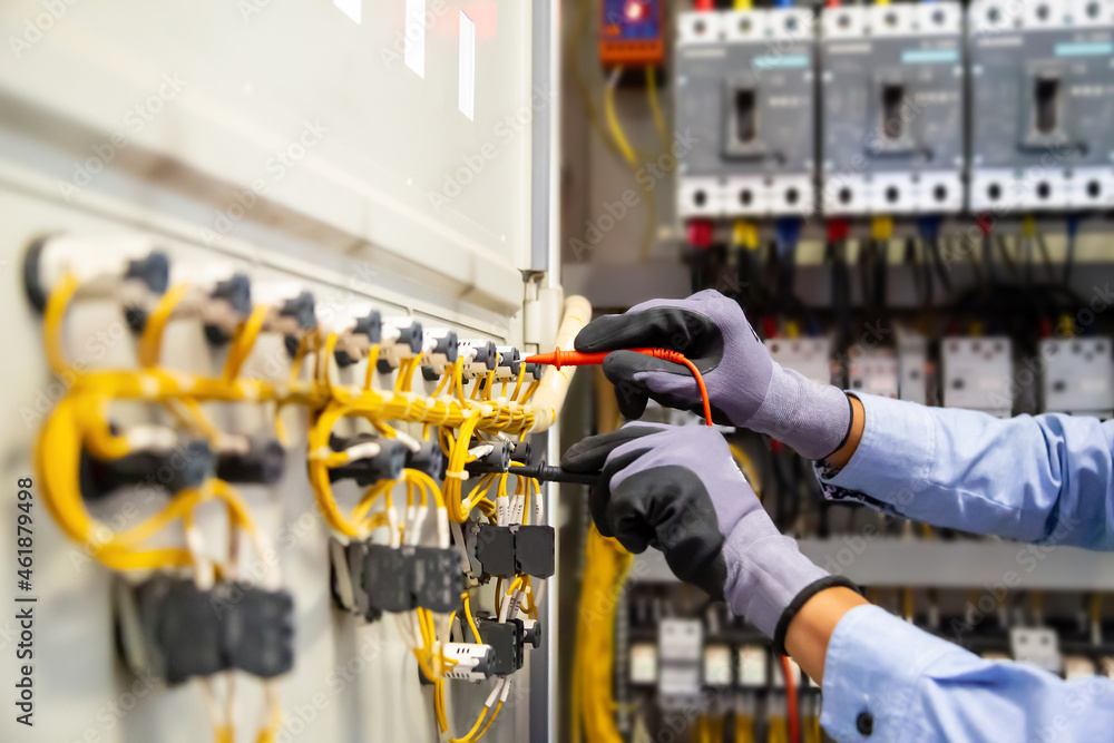 Electrical engineer using digital multi-meter measuring equipment to ...