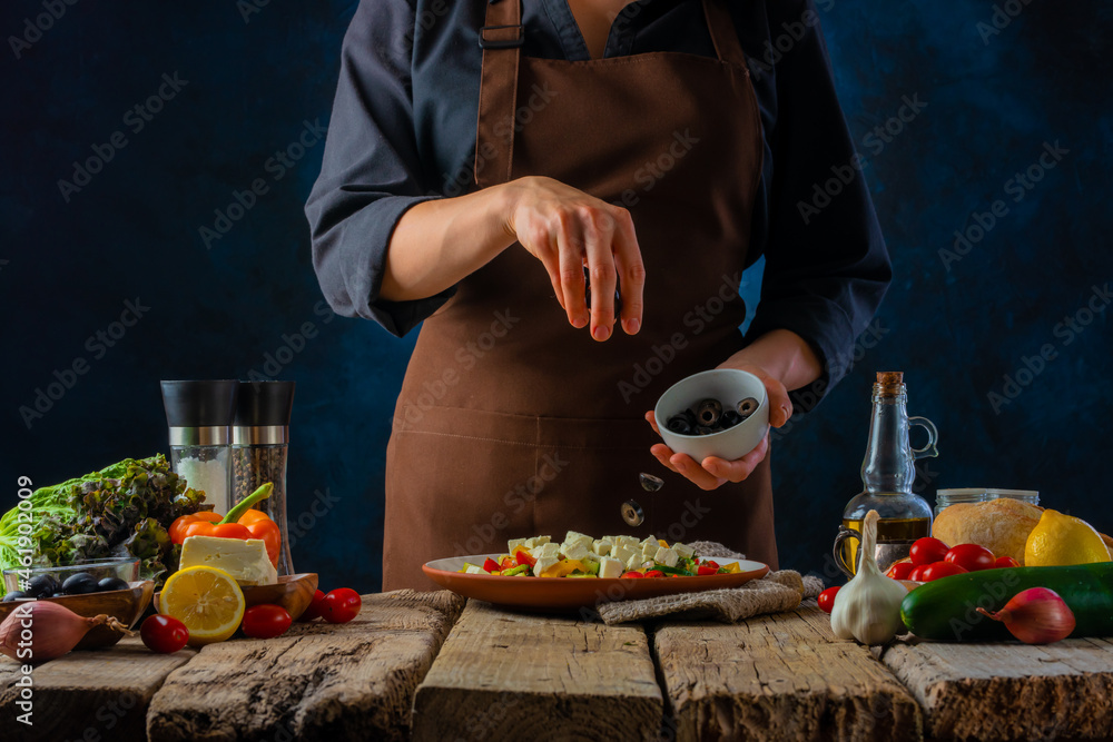 The chef adds the olives to the bowl. Lots of ingredients. Cooking ...