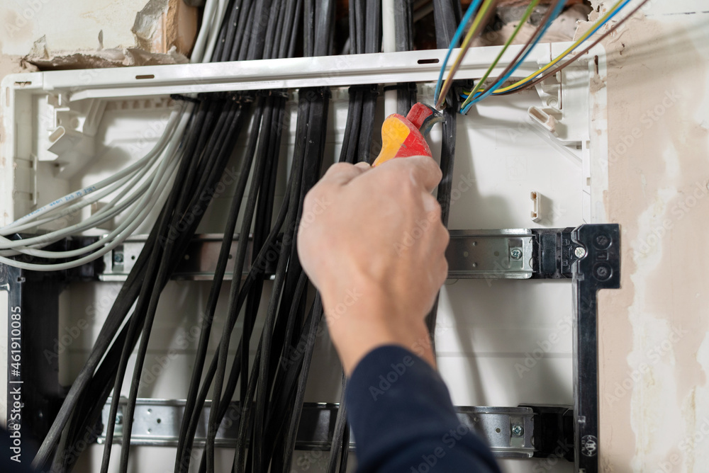 Dangerous work with electricity. The electrician installs the ...