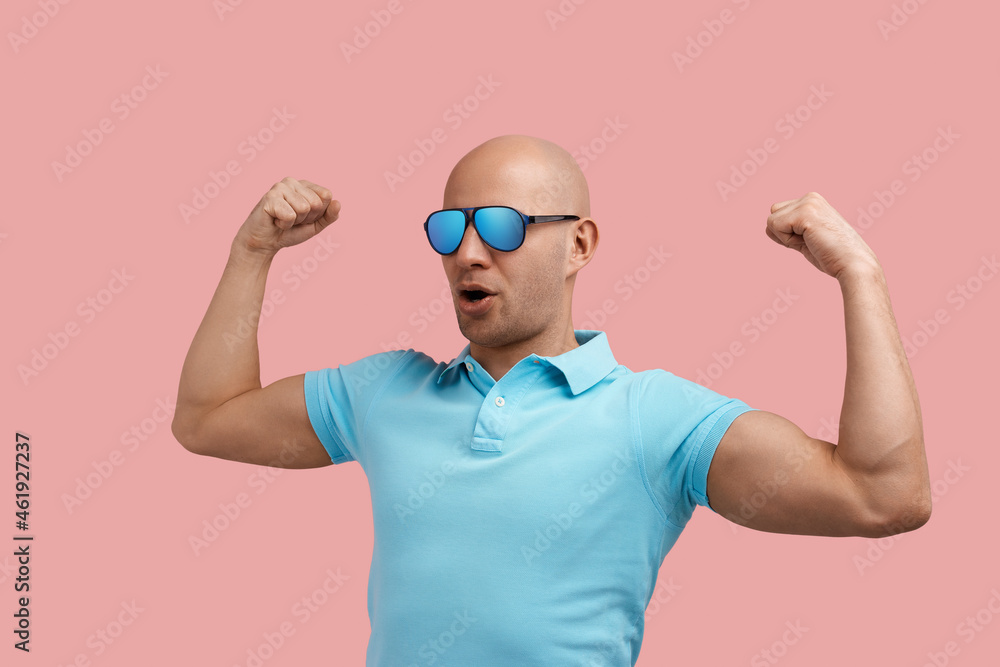 Fitness addicted strong bald homosexual man with bristle shows muscles ...