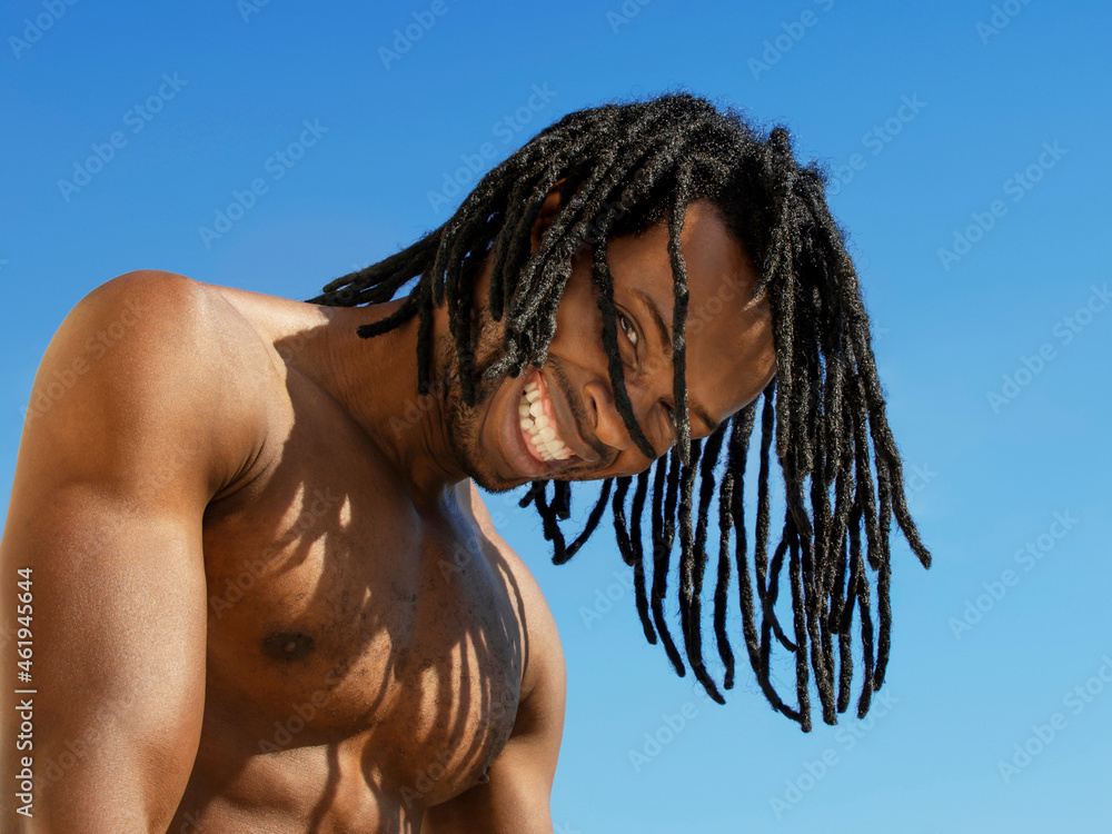Handsome man smiling under the sun at the beach, blue sky, photo ...