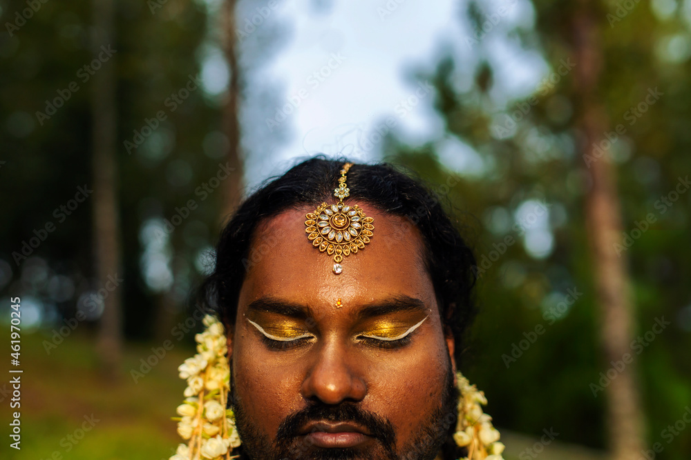 portrait of dark skinned Indian non-binary individual with traditional ...