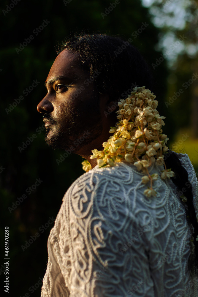 portrait of dark skinned Indian non-binary individual with traditional ...