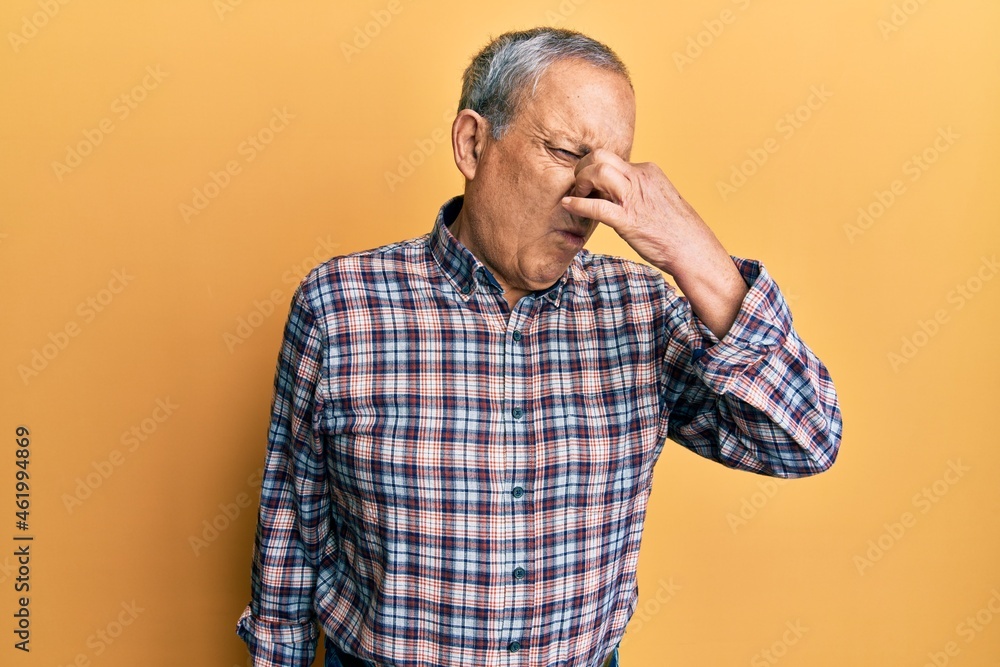 Handsome senior man with grey hair wearing casual shirt smelling ...