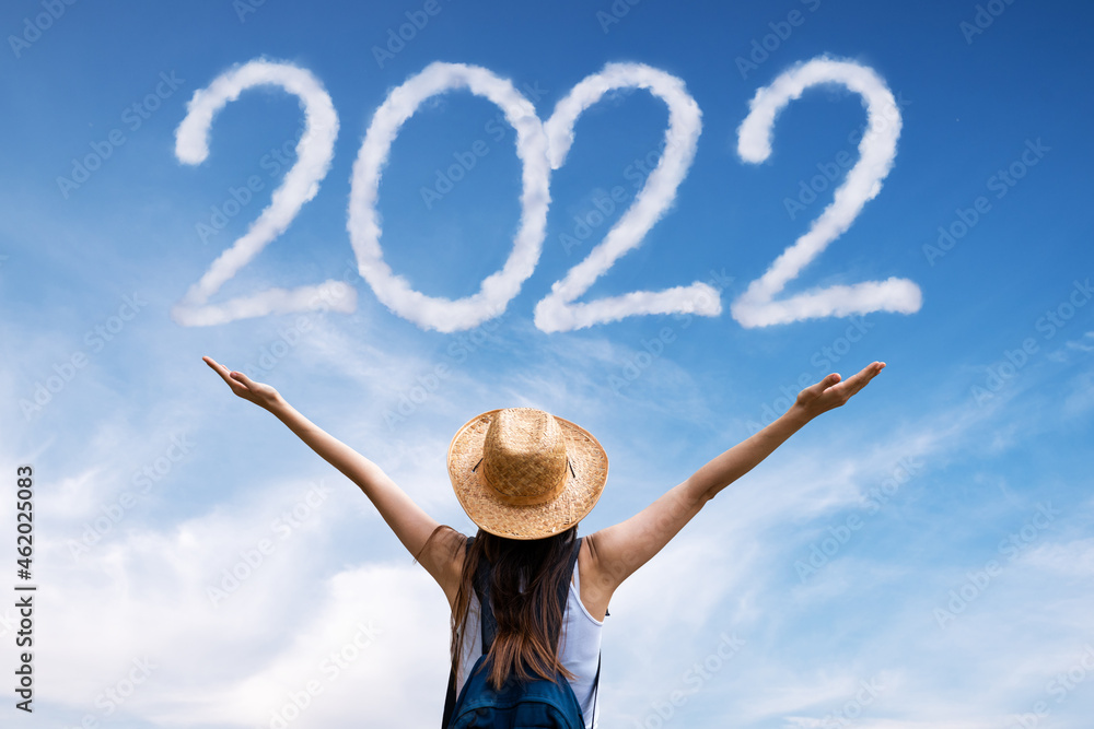Brunette woman greets the 2022 against clouds Stock Photo | Adobe Stock
