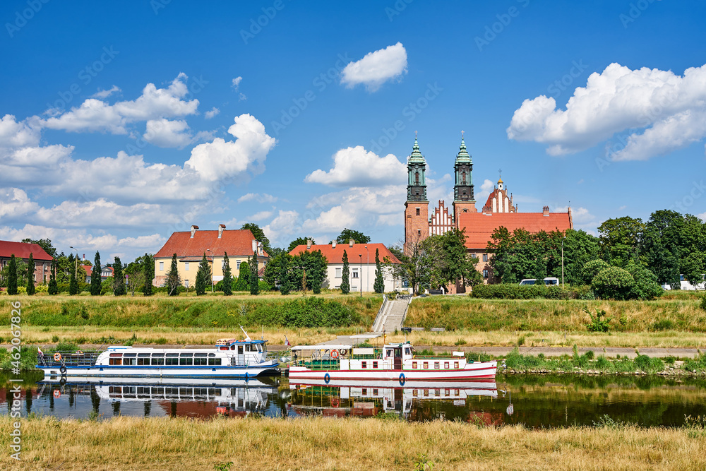 Cruise ships on the Warta River and the bell towers of the historic ...