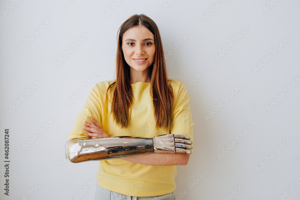 Pretty smiling blonde young woman with elegant bionic prosthesis arm ...