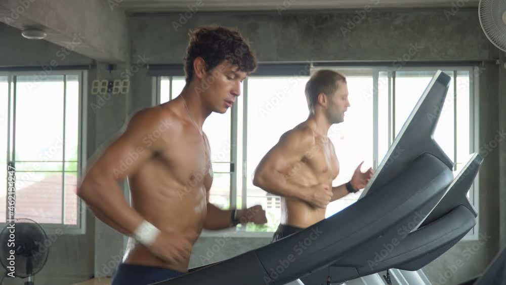 group of two muscular man running on treadmill in fitness gym at sport ...