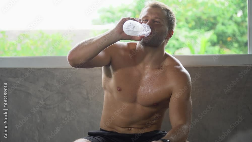 Handsome muscular man running sitting on treadmill finished exercise ...