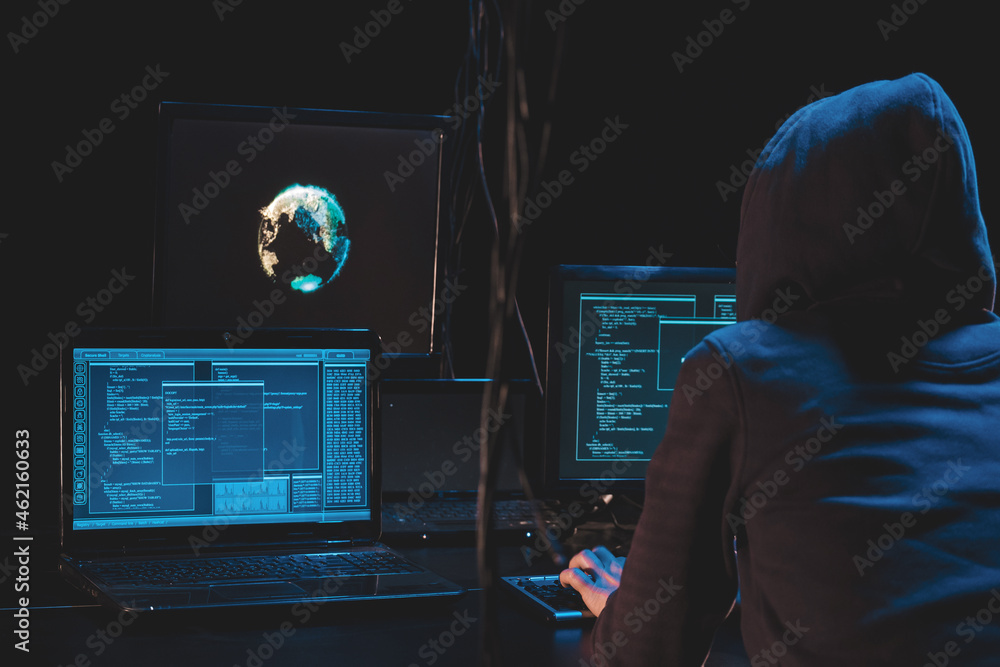 Back hooded hacker using malicious software hack corporate data center ...