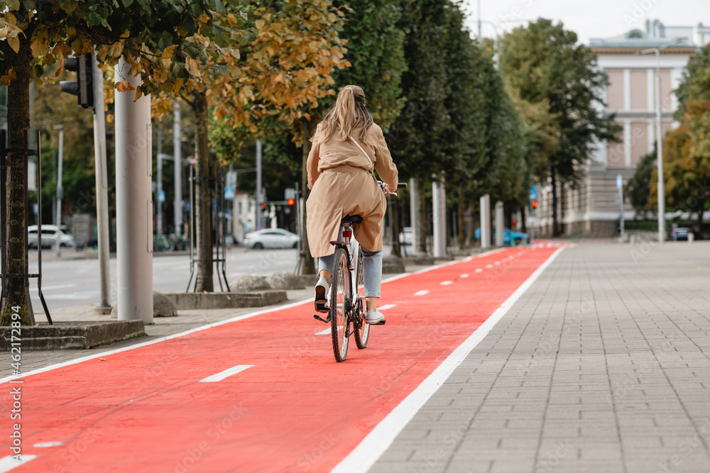 traffic, city transport and people concept - woman riding bicycle along ...