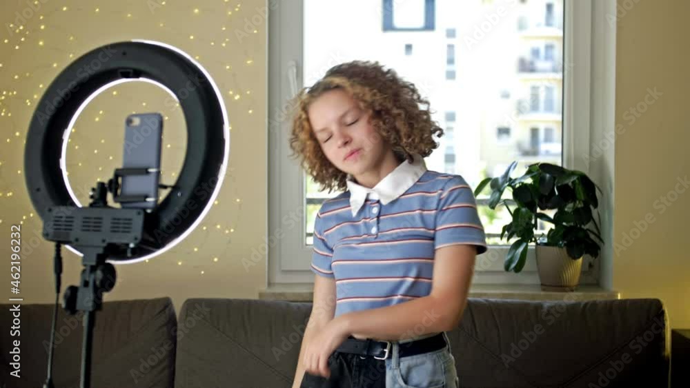 Cheerful teen girl dancing at camera filming video using phone on ...