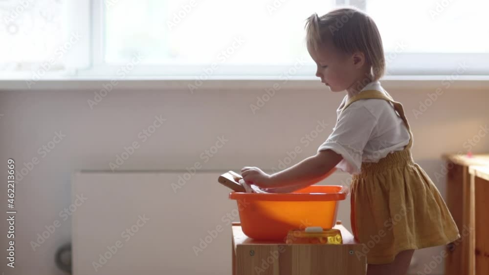 Cute child girl washing clothes, doll clothes, rag in a basin, sensory ...