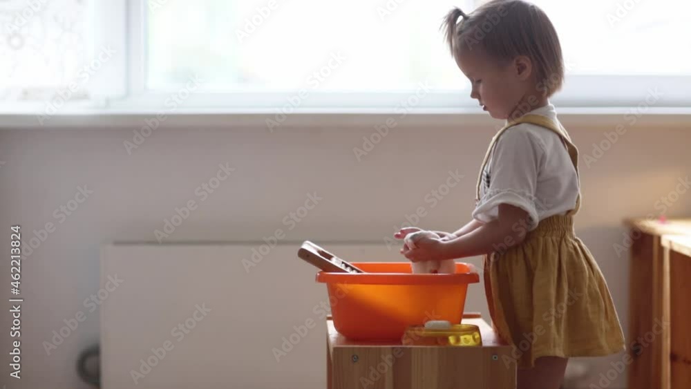 Cute child girl washing clothes, doll clothes, rag in a basin, sensory ...