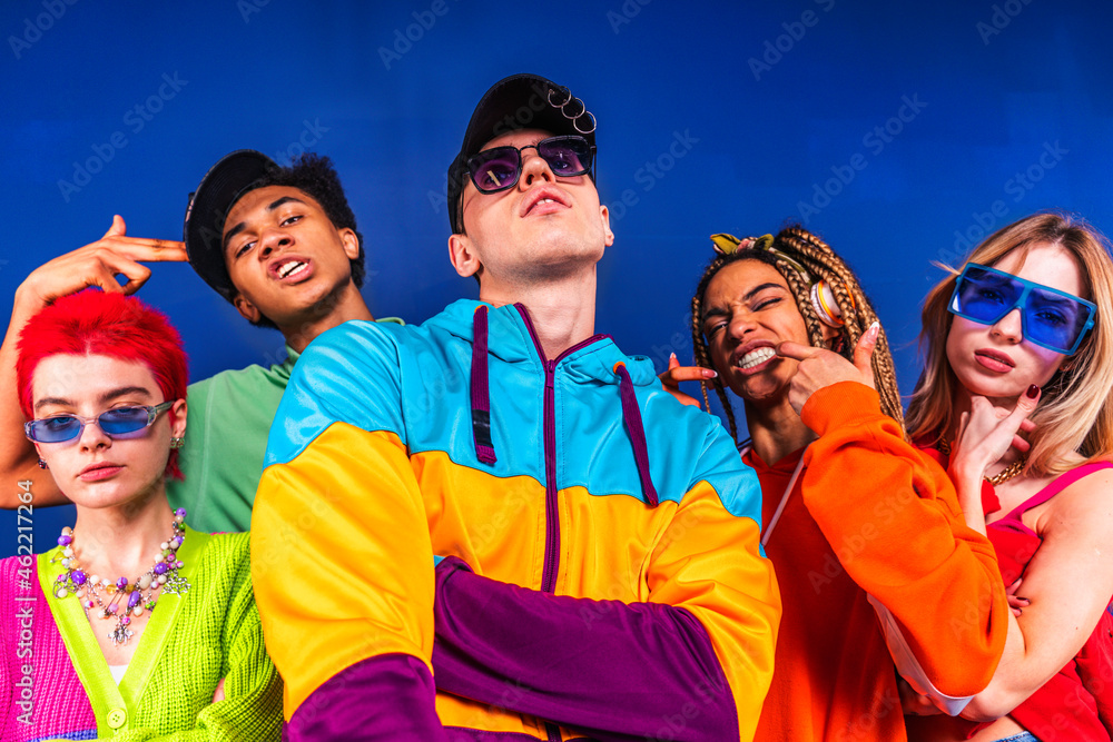 Cool friends with cap and sunglasses standing in front of blue ...