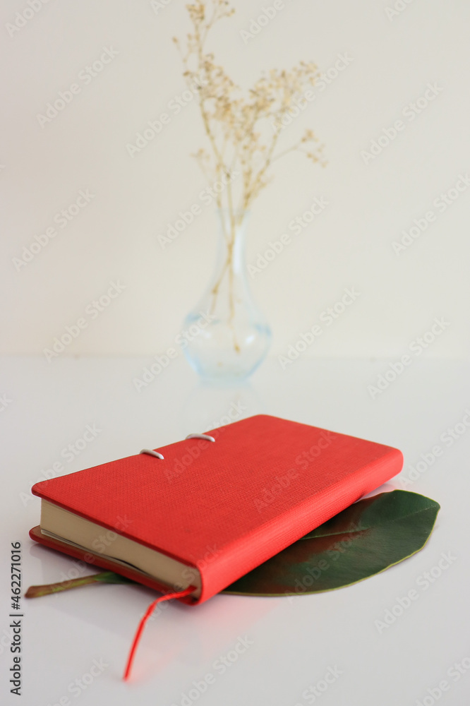 notepad and leaves on table. notepad on white background. gypsophilus ...