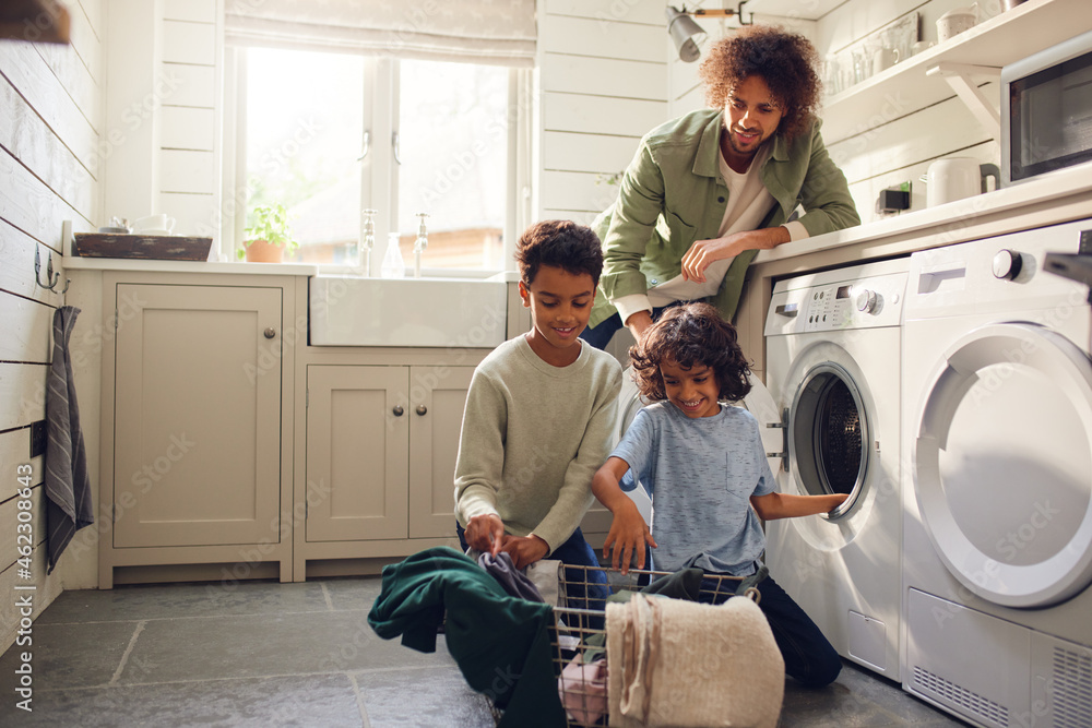 Boys doing laundry with father watching Stock Photo | Adobe Stock
