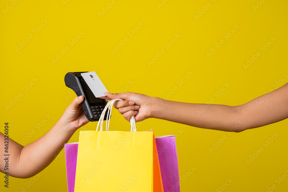 mano de una mujer pagando las compras con una tarjeta en un dispositivo ...