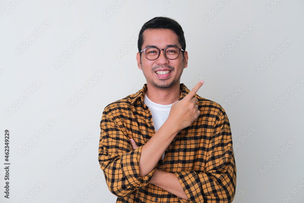 Adult Asian man pointing finger to the left with smiling face Stock ...