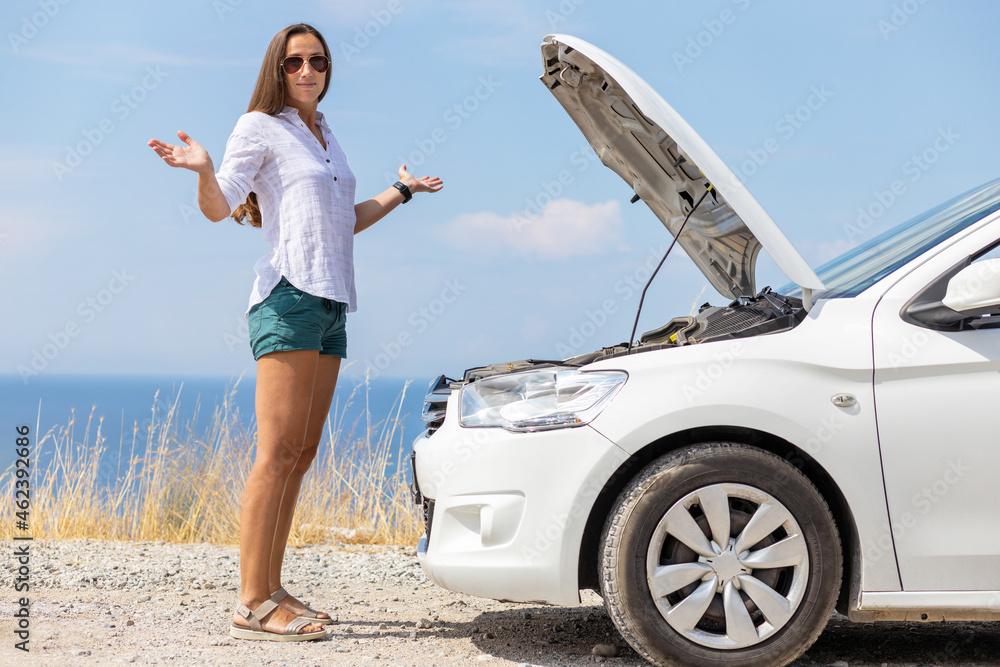 Young slim woman standing embarrassed near her car during summer ...